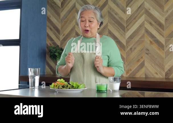Asian healthy senior woman cooking simple food in kitchen at home in ...