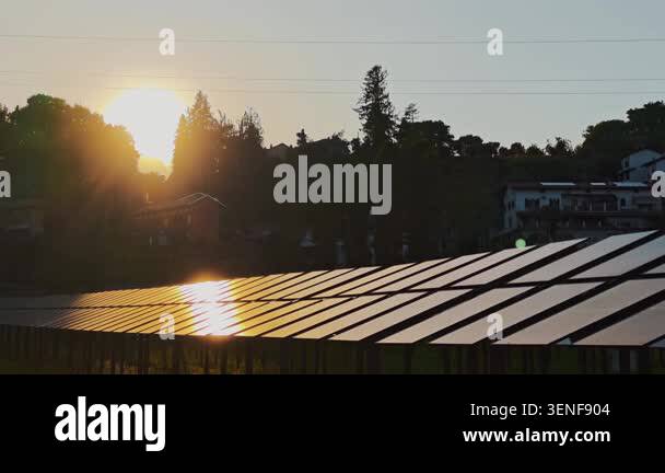 Expansive rooftop solar installation with sun reflection glowing on ...