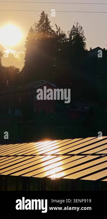 Rooftop photovoltaic installation against deep dramatic sunset sky with ...