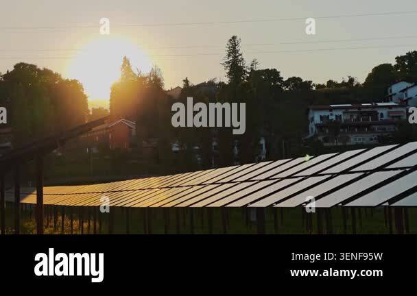Close view of photovoltaic panels with warm golden sun setting behind ...