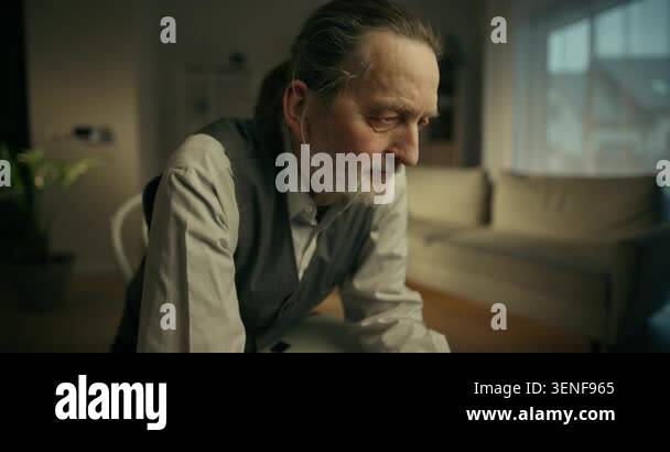 Side view of an elderly man with gray hair and beard sitting in a ...