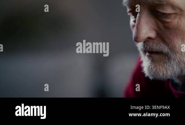 Close-up profile of an elderly bearded man with a thoughtful expression ...