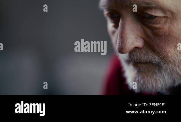 Close-up of an elderly bearded man with a serious, contemplative ...