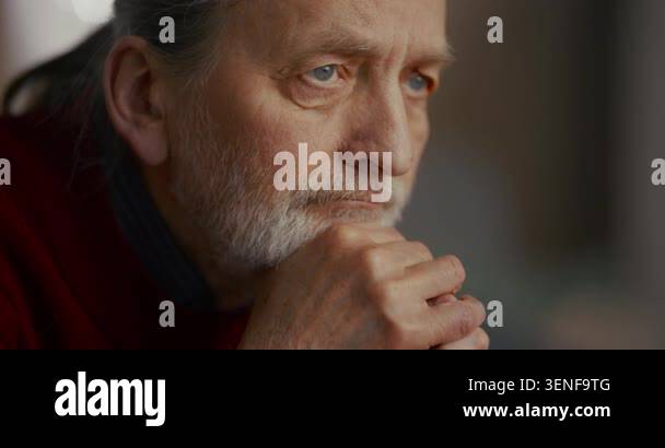 Close-up portrait of an elderly man with a gray beard and blue eyes in ...