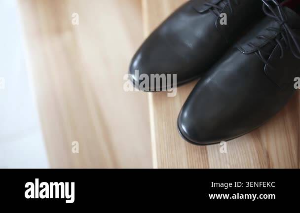 Pair of polished black formal shoes viewed from above on a light wooden ...