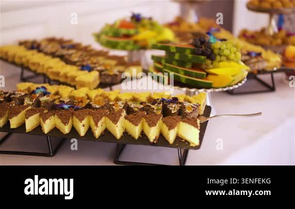 Assorted cakes, pastries, and fresh fruit platters arranged on serving ...