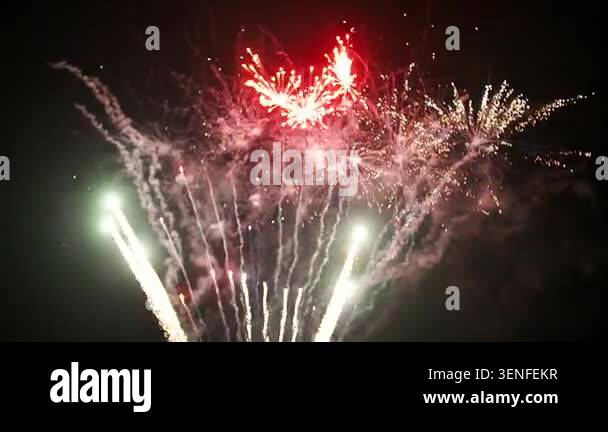 Bright fireworks bloom against a dark sky with red, white, and gold ...