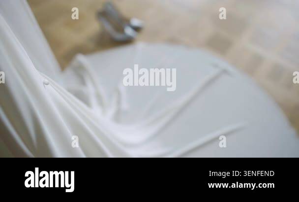 Softly blurred close-up of a white toilet seat in the foreground of a ...