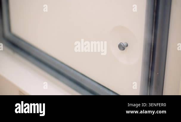 Close-up of a small metal or bolt mounted beside the edge of a glass ...