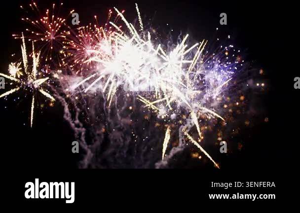 Bright red, white, and purple fireworks bloom across the dark sky with ...