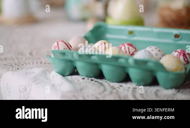 Decorated eggs rest in a teal carton on a lace tablecloth, with soft ...