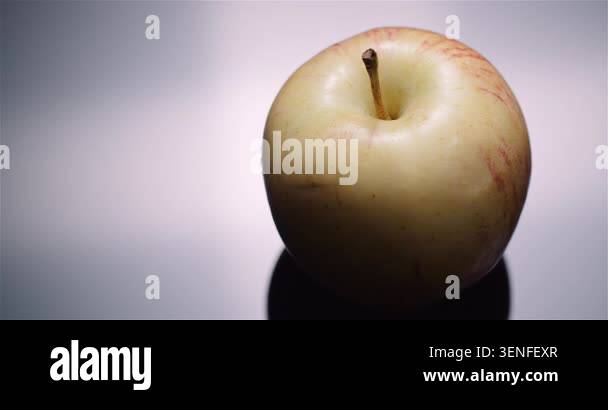 A single ripe apple sits near the upper right on a clean pale ...