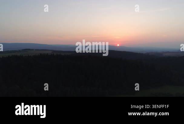 Calm evening landscape with the sun near the horizon, layered distant ...