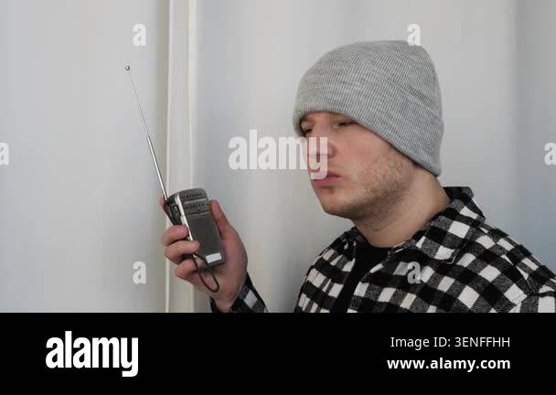 A man holding a radio in his hand, listening to a portable radio, news ...