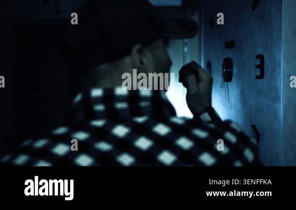A man in a dark room with a flashlight in his hand, fear, horror in a ...