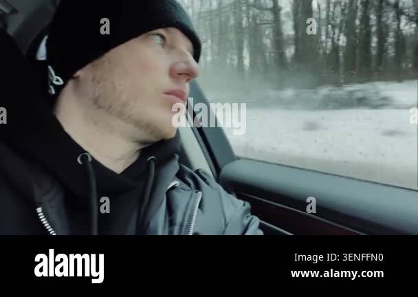 A sad man sitting in a car, a young guy looking out the window from the ...