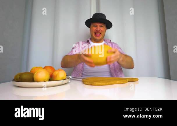 Stylish Man in a hat with a smile with a melon in his hands on the ...