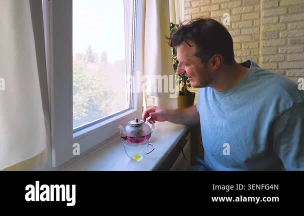 Pour red tea from a teapot into a transparent cup. China ceremony near ...