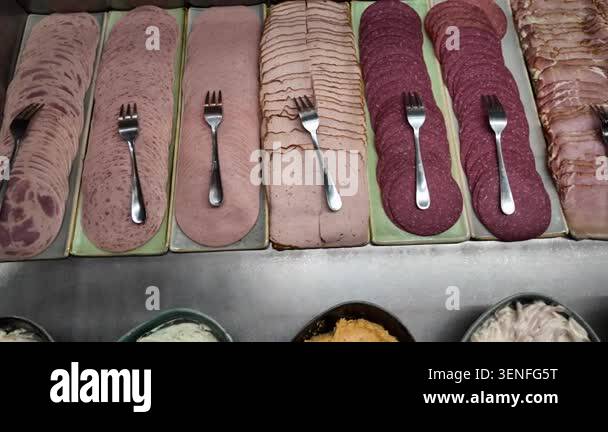Top view of various types of sliced sausages and cold cuts with serving ...