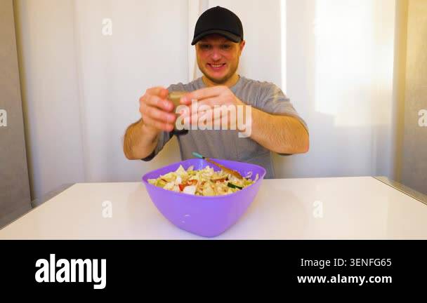 A man prepares a salad from vegetables and fresh cabbage. Cooking food ...