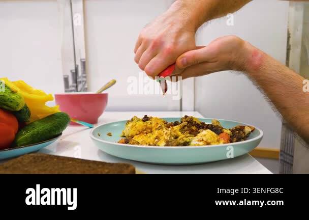 Sprinkling ketchup on food in a plate, a delicious omelette in a plate ...