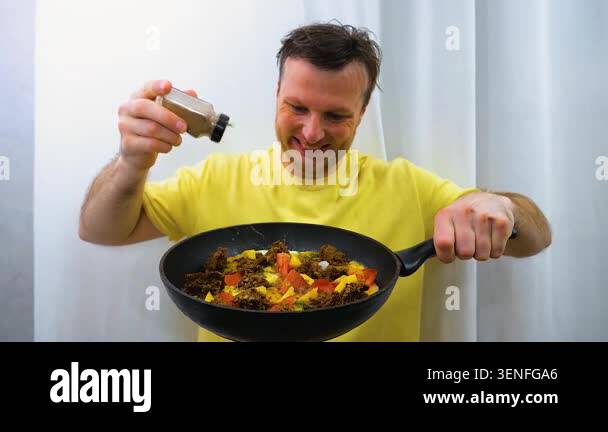 Man Pepper the omelet with tomato in a frying pan. Cooking food in a ...