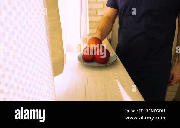 A man with fruit in his hands. Nectarine or peach in a plate in a ...