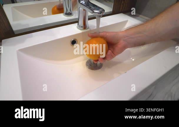 Wash a ripe orange under the tap of water, wash the orange in its peel ...