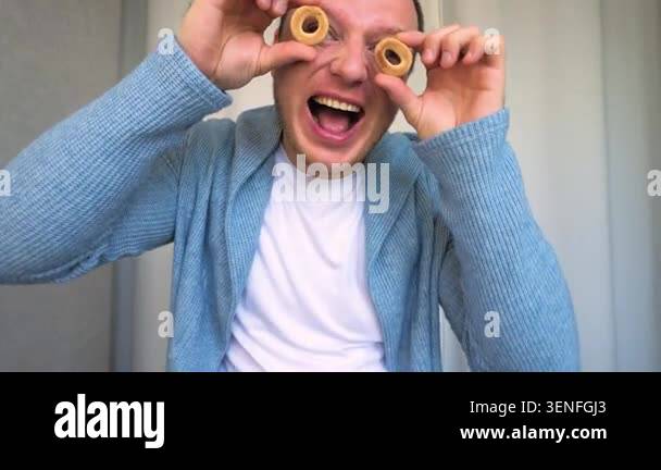 Happy man with a smile with food in his hands. The guy eats bagel ...