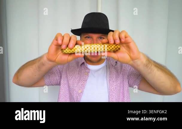 Breaking a wafer roll with condensed milk with his hands, a stylish man ...