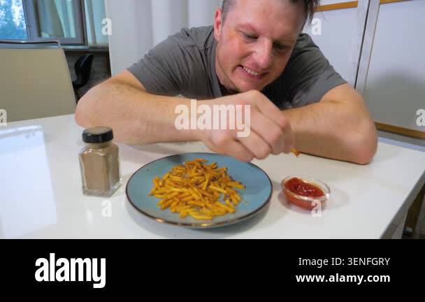Man eating French fries in slow motion. Eat fried chips with red ...