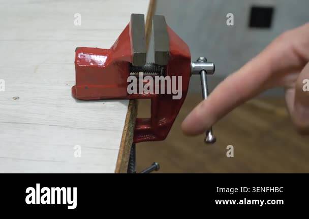 A mini vice on a workbench, a worker opens the metal vice Stock Video ...