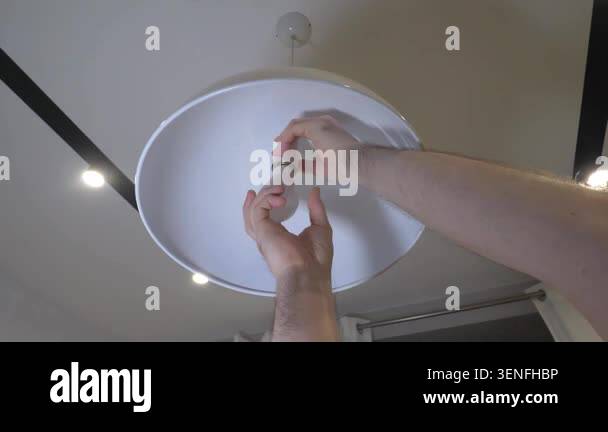 Screwing a lamp into a socket. Replacing a light bulb in a modern ...