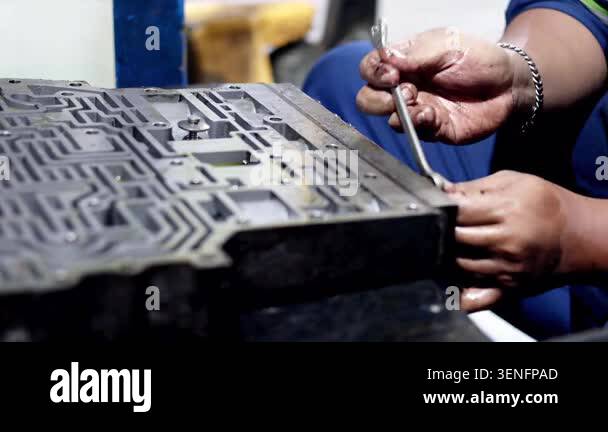 Close up of mechanic hands using a tool to dismantle and fix a car ...