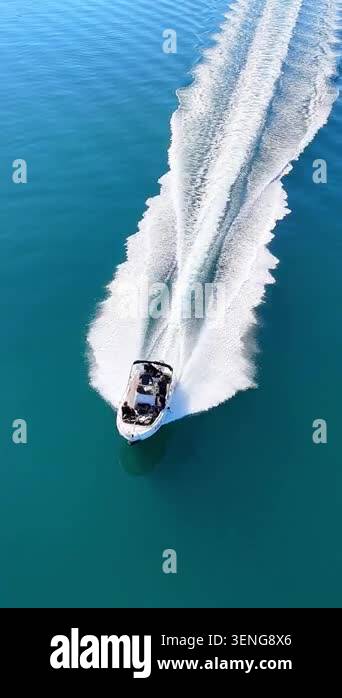 Top down drone shot of a speedboat moving through calm blue water Stock ...