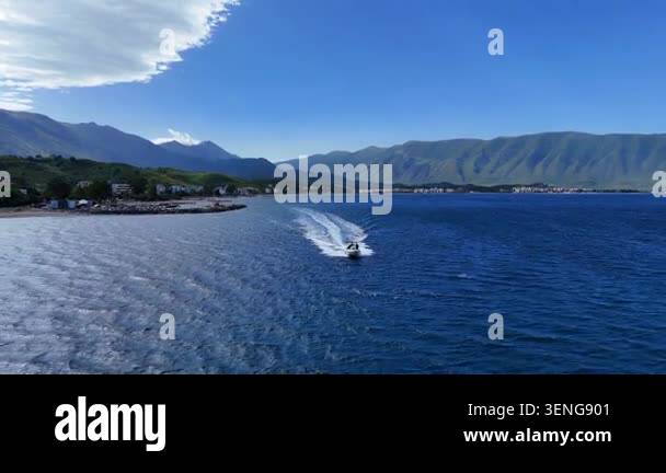 Front view of a speedboat moving away from the coast with marina ...