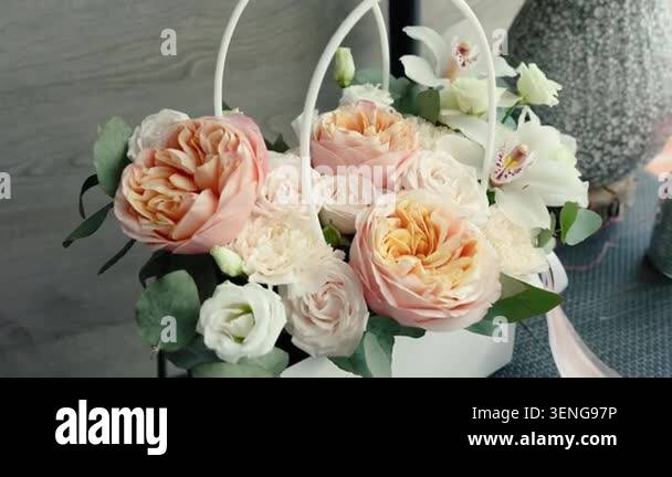 A beautiful romantic bouquet of unusual white roses in a handbag. A ...