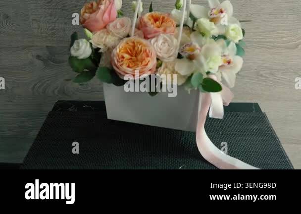 A beautiful romantic bouquet of unusual white roses in a handbag. A ...