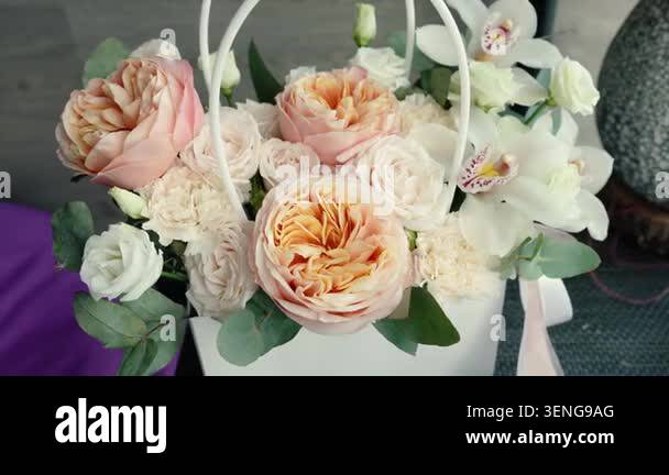 A beautiful romantic bouquet of unusual white roses in a handbag. A ...