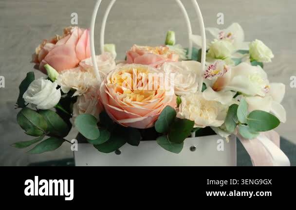 A beautiful romantic bouquet of unusual white roses in a handbag. A ...