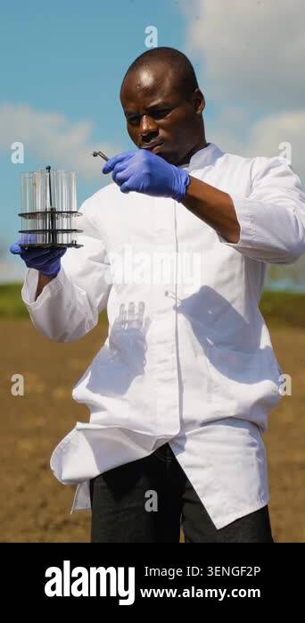 Agricultural scientist collecting soil samples in test tubes for ...