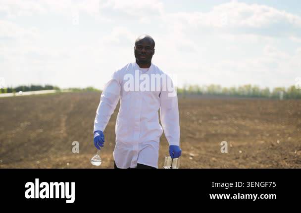 African american male laboratory worker in a white coat and gloves ...
