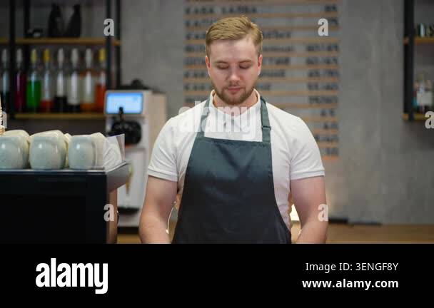 Portrait of a young male coffee shop owner standing with arms crossed ...