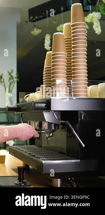 Professional barista operating an espresso machine in a modern coffee ...