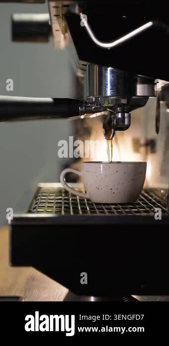 Close up view of a professional espresso machine pouring hot, steaming ...