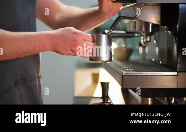 Unrecognizable male barista using a steam wand on a professional ...