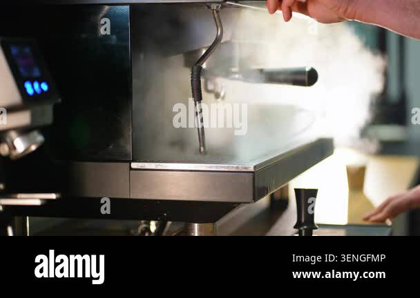 Professional baristas hand releasing hot steam from a coffee machine ...