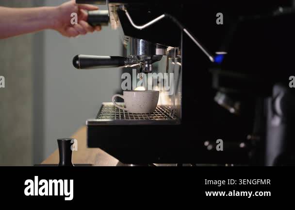 Professional barista making a fresh cup of espresso. Hot steam rises as ...