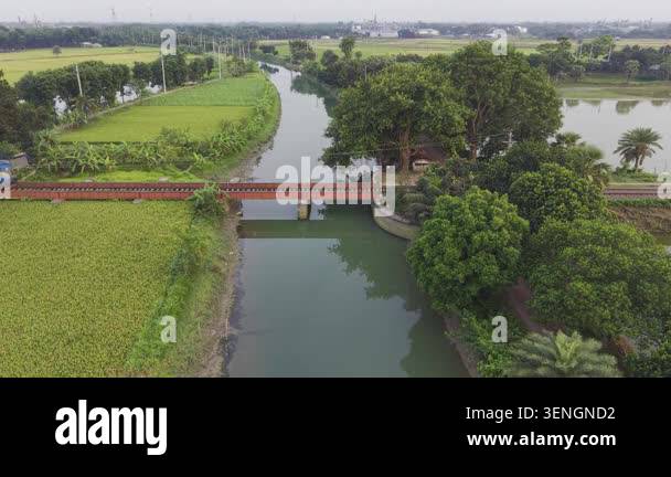 Aerial Drone View of a Passenger Train Crossing a Canal Bridge in Rural ...