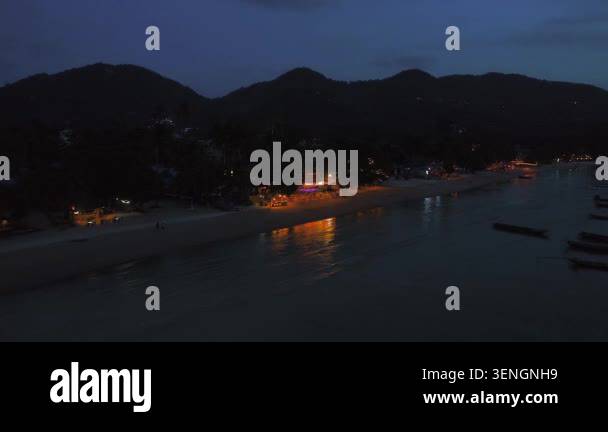 Aerial drone footage flying over a calm sea towards a tropical beach at ...
